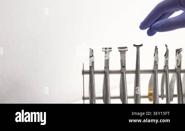 Orthodontic forceps arranged on dental clinic workstation surface with ...