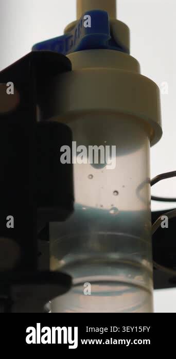 Macro close up of IV infusion chamber showing a liquid drop forming ...