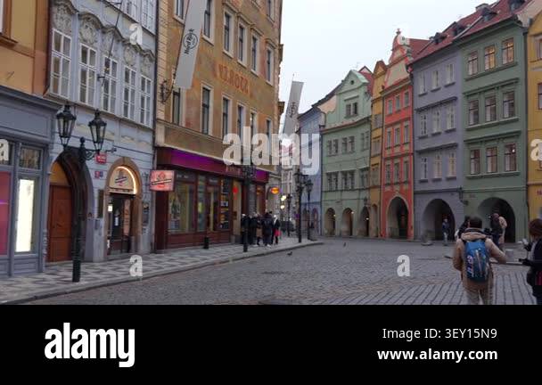 Tourists walk past colorful historic facades on cobblestone Old Town ...