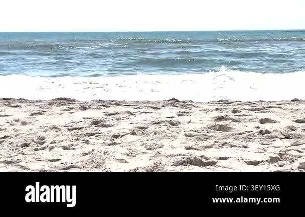 Front view of Atlantic Ocean waves rolling on to the sand on Fire ...