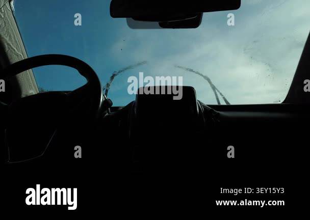 Self-service car wash, person washes windshield with high pressure ...
