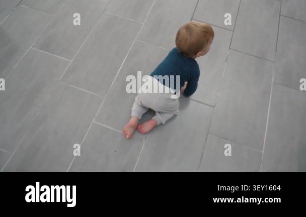 Child moving on tiled floor towards brightness. Toddler crawling in ...