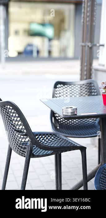 Arranged metal and plastic outdoor furniture leaning against a wall ...