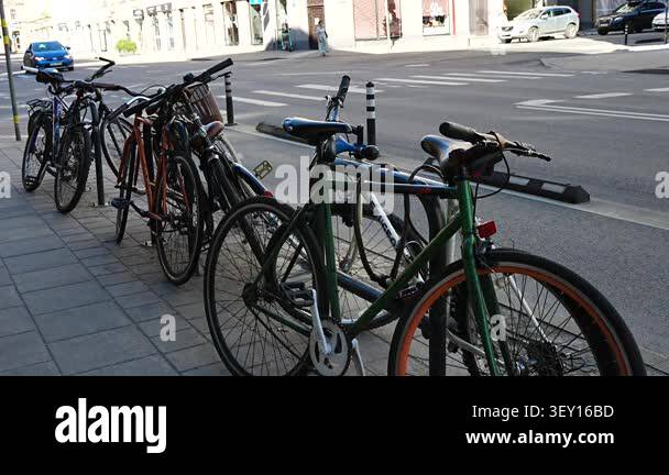 Several city bikes locked together on a street side parking frame ...