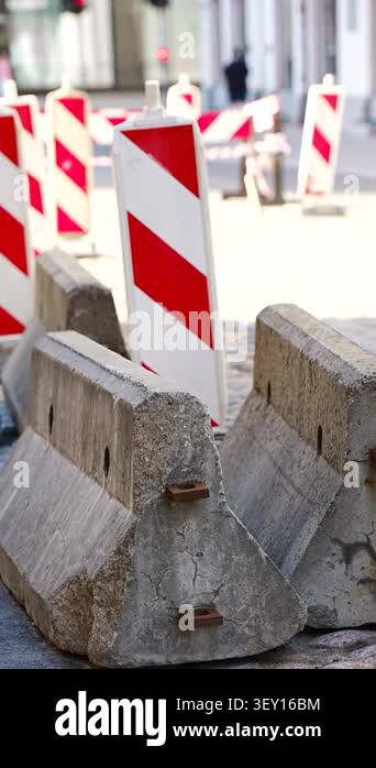Solid concrete road barriers aligned with diagonal striped warning ...
