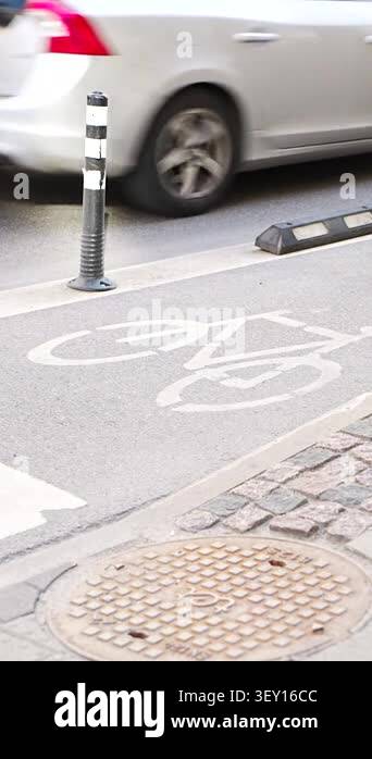 Urban bicycle transit lane painted icon on a road surface alongside ...