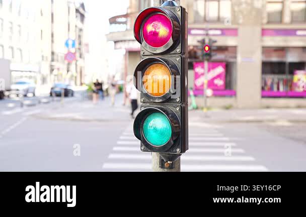 A black traffic signal pole standing at a pedestrian intersection ...