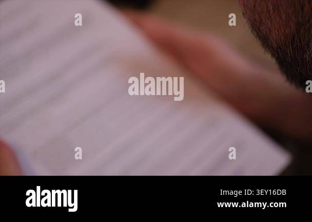 Close up footage of a man reviewing printed documents and turning pages ...