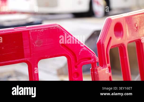 Bright red plastic safety barriers linked together at an urban roadwork ...
