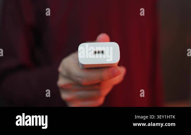 Close Up of Hand Holding USB Wall Charger Adapter with Blurred ...