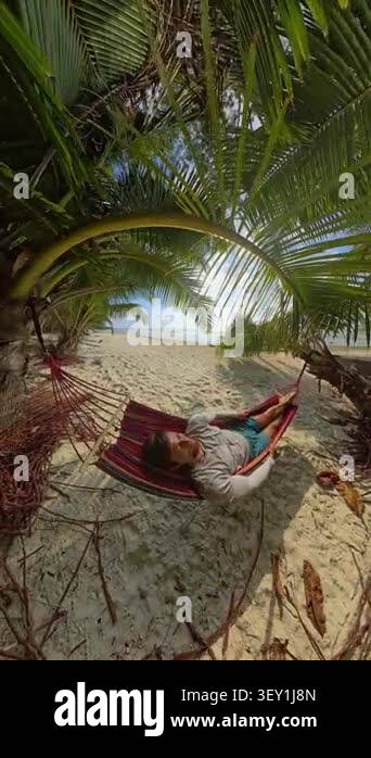 Vertical video. Tropical Palm Shade Relaxation, Man Resting in Red ...