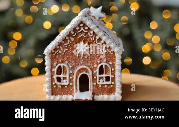 gingerbread house on a wood slice against a background of gold fairy ...
