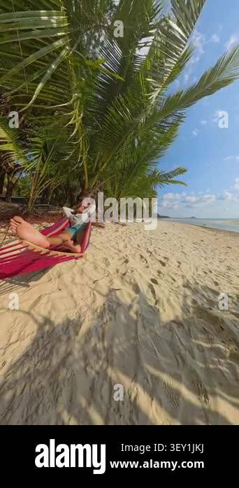 Vertical video. Tropical Beach Rest, Man Lying in Red Hammock Facing ...