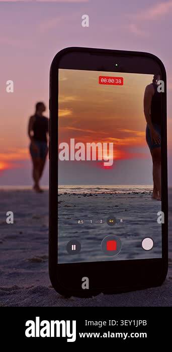 Vertical video. Smartphone Recording Couple Walking Past Camera on ...