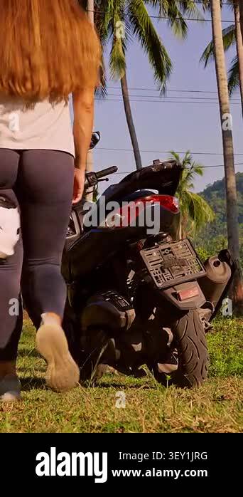 Vertical video. Young Woman Standing Near Scooter Holding Helmet in ...