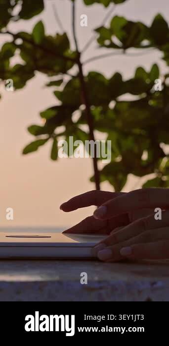 Vertical video. Young Woman Opening Laptop at Seaside Table During ...