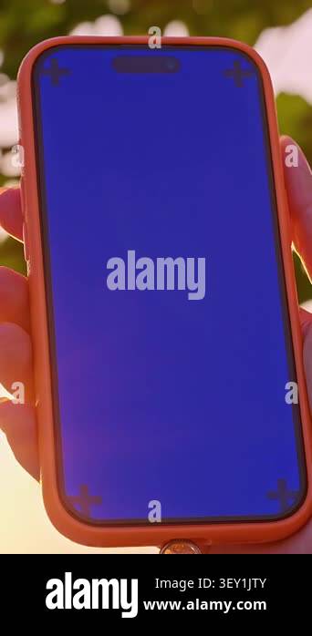 Vertical video. Hand Holding Smartphone with Blank Blue Screen Against ...