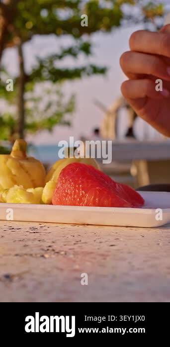 Vertical video. Close Up of Hand Picking Juicy Pomelo Slice from Plate ...