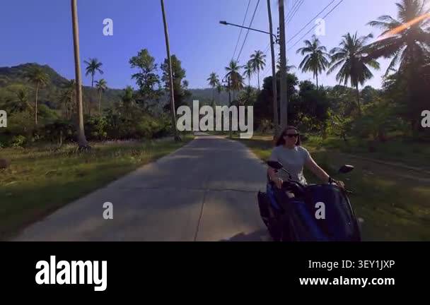 Low Angle Front View of Young Woman Riding Scooter With Headlights on ...