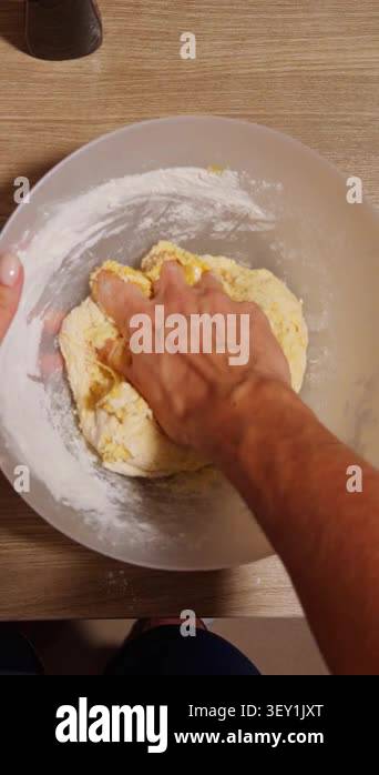 Vertical video. Hands Kneading Soft Dough Inside Large Bowl On Wooden ...