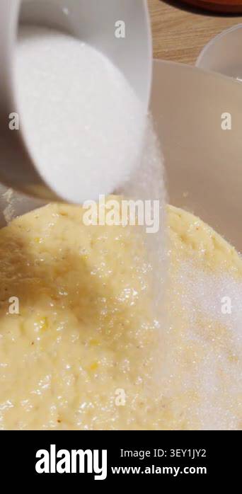Vertical video. Sugar Being Poured Into Soft Dough Mixture In Large ...