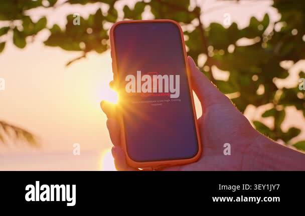 Smartphone Screen Showing Overheating Warning Message in Hand at Sunset ...