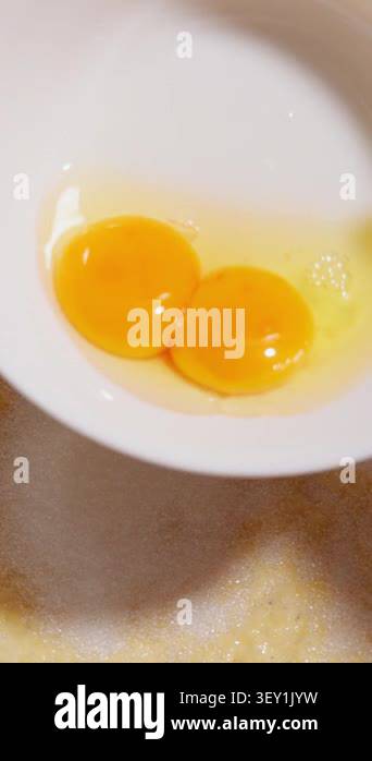 Vertical video. Eggs Being Added Into Sweet Dough Mixture Inside Large ...