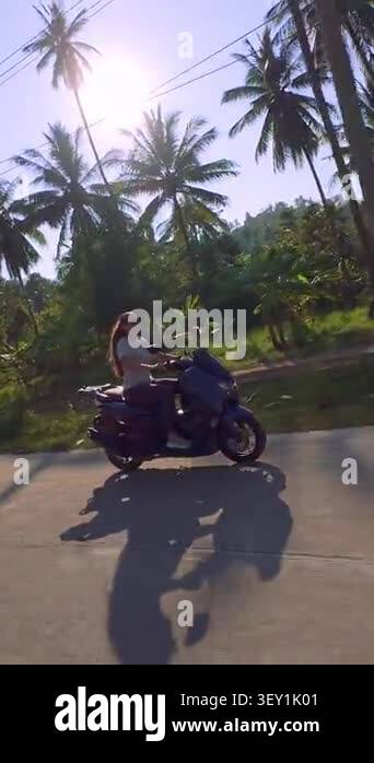 Vertical video. Close Side View of Young Woman Riding Scooter With ...