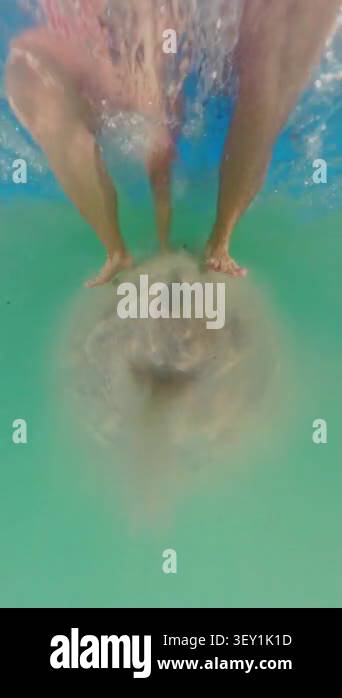 Vertical video. Underwater Close View Couple Walking On Sandy Bottom ...