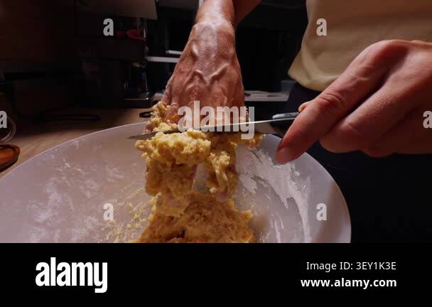 Hands Removing Sticky Dough From Fingers Using Knife Above Large Bowl ...