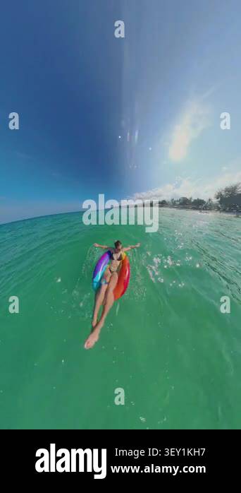 Vertical video. Woman Floating On Inflatable Ring In Open Sea With ...
