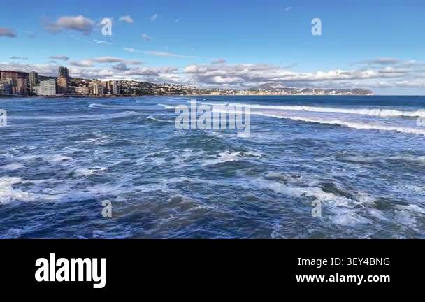 Aerial ocean waves urban coastline foam rolling toward shore, city ...