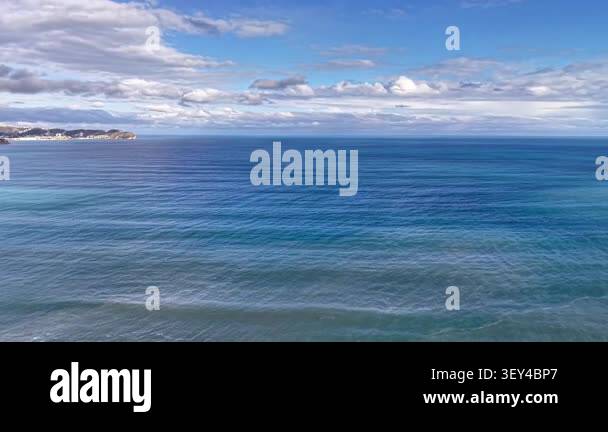 Calm ocean horizon with soft cloudscape, wide aerial panorama of glassy ...
