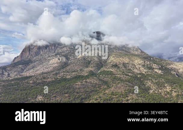 Cloudcapped mountain with dramatic sky, thick fog hugging summit ...