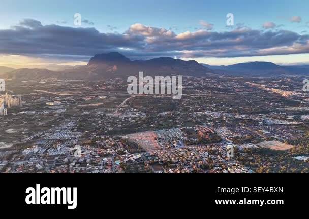 Sunrise aerial over mountainous cityscape, showing sprawling suburbs ...