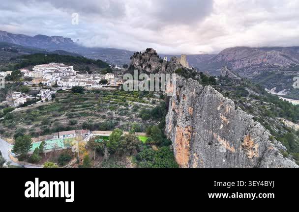 Aerial village perched on limestone ridge, dramatic overcast sky ...