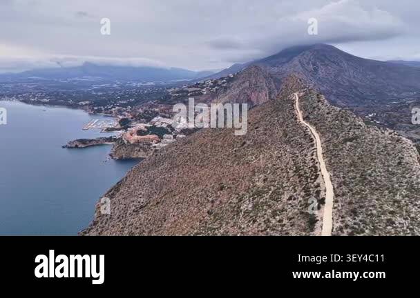 Aerial drone view ridge trail along cliff overlooking harbor and ...