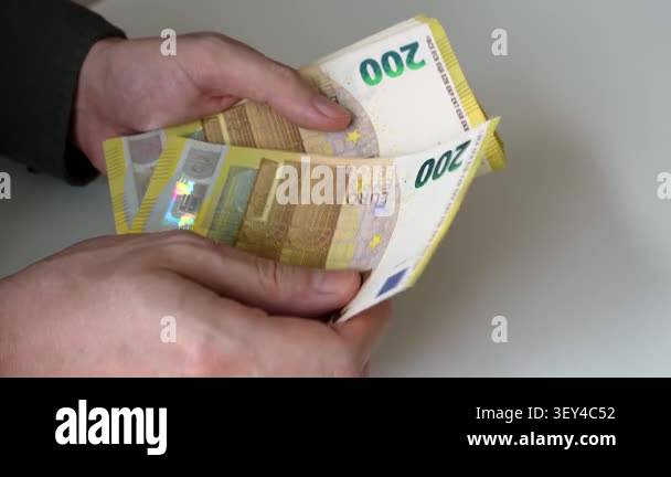 Person counting a bundle of 200 euro notes in close-up. European cash ...