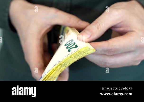 Person counting a bundle of 200 euro notes in close-up. European cash ...