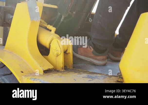 Operator is seen getting ready to use a forklift truck in warehouse ...