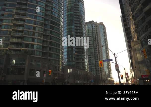 Pedestrians crossing a busy downtown intersection between modern glass ...