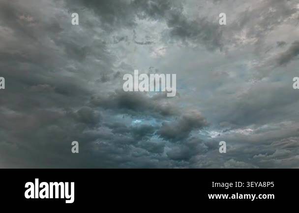 Dramatic storm cloudscape with rainbow appearing through dark grey ...