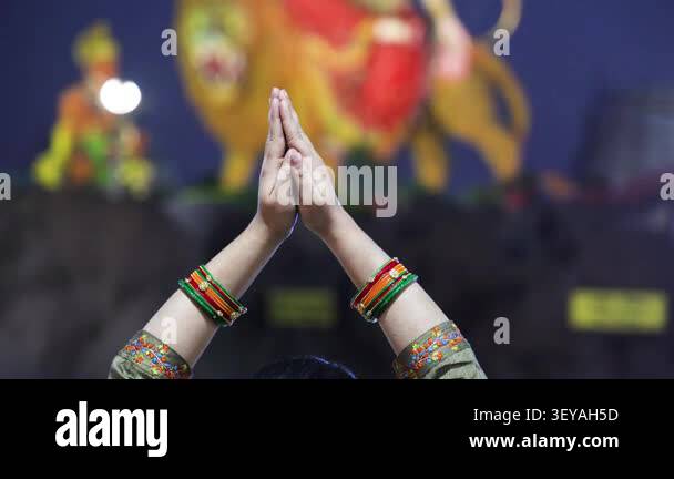 woman offering prayer with folded hands before goddess durga idol ...