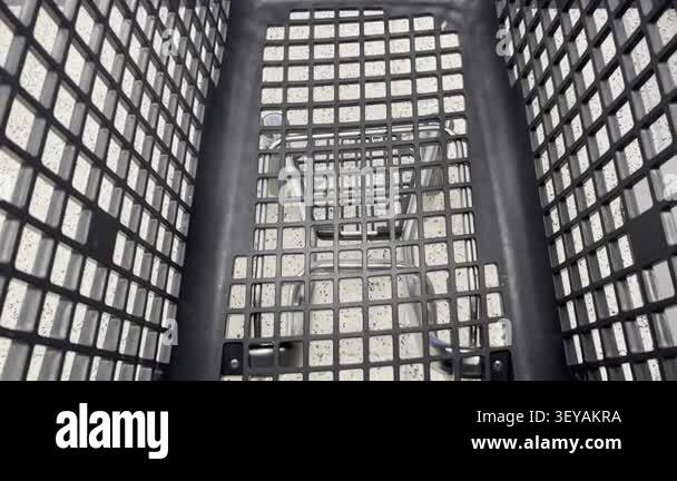 Black plastic laundry basket with a grid pattern is shown from above ...
