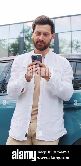 Man using a smartphone app to monitor and control the charging of an ...