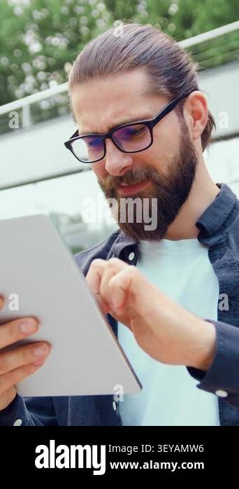 Portrait of old business man on city street working on digital tablet ...