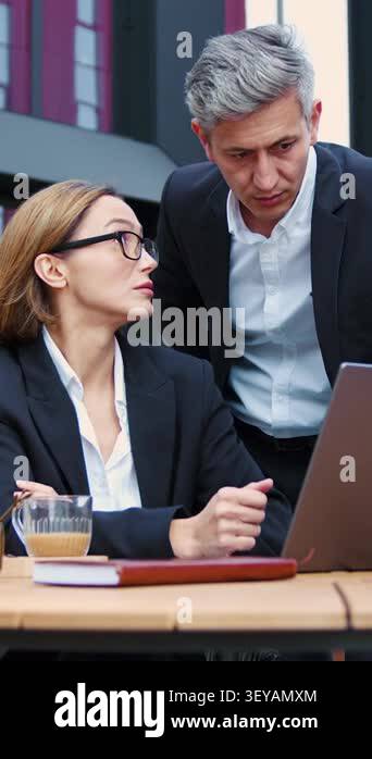 Professional man woman using laptop discussing project sitting in cafe ...