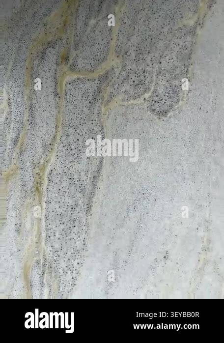 Natural foamy, marble-like patterns move slowly on the water's surface ...