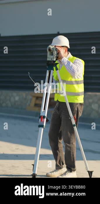 Professional surveyor working with a theodolite total station and a ...