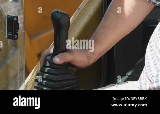 Close-up of a crane operator controlling a mobile crane with a joystick ...